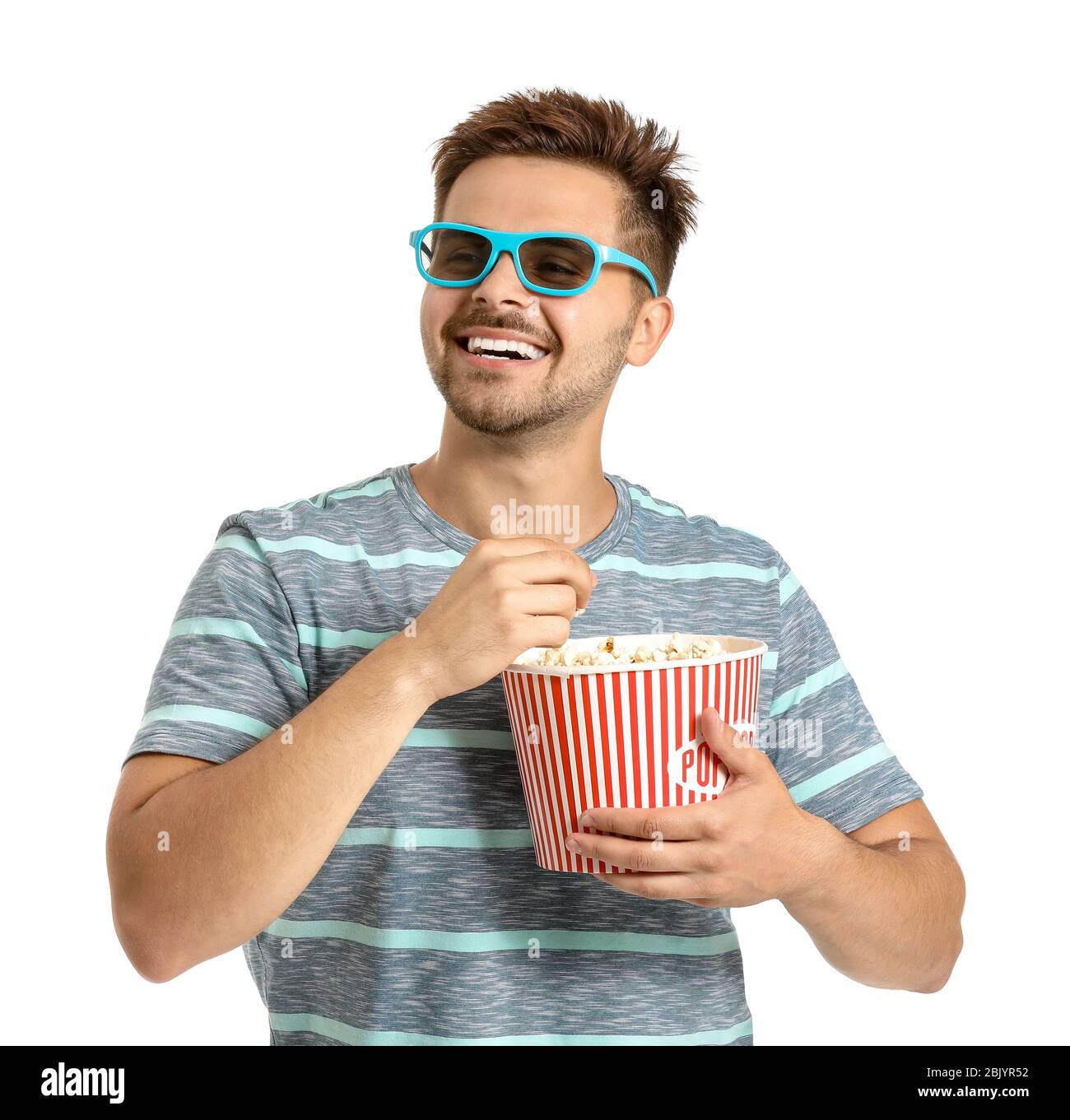 Young man with popcorn watching movie on white background Stock Photo ...
