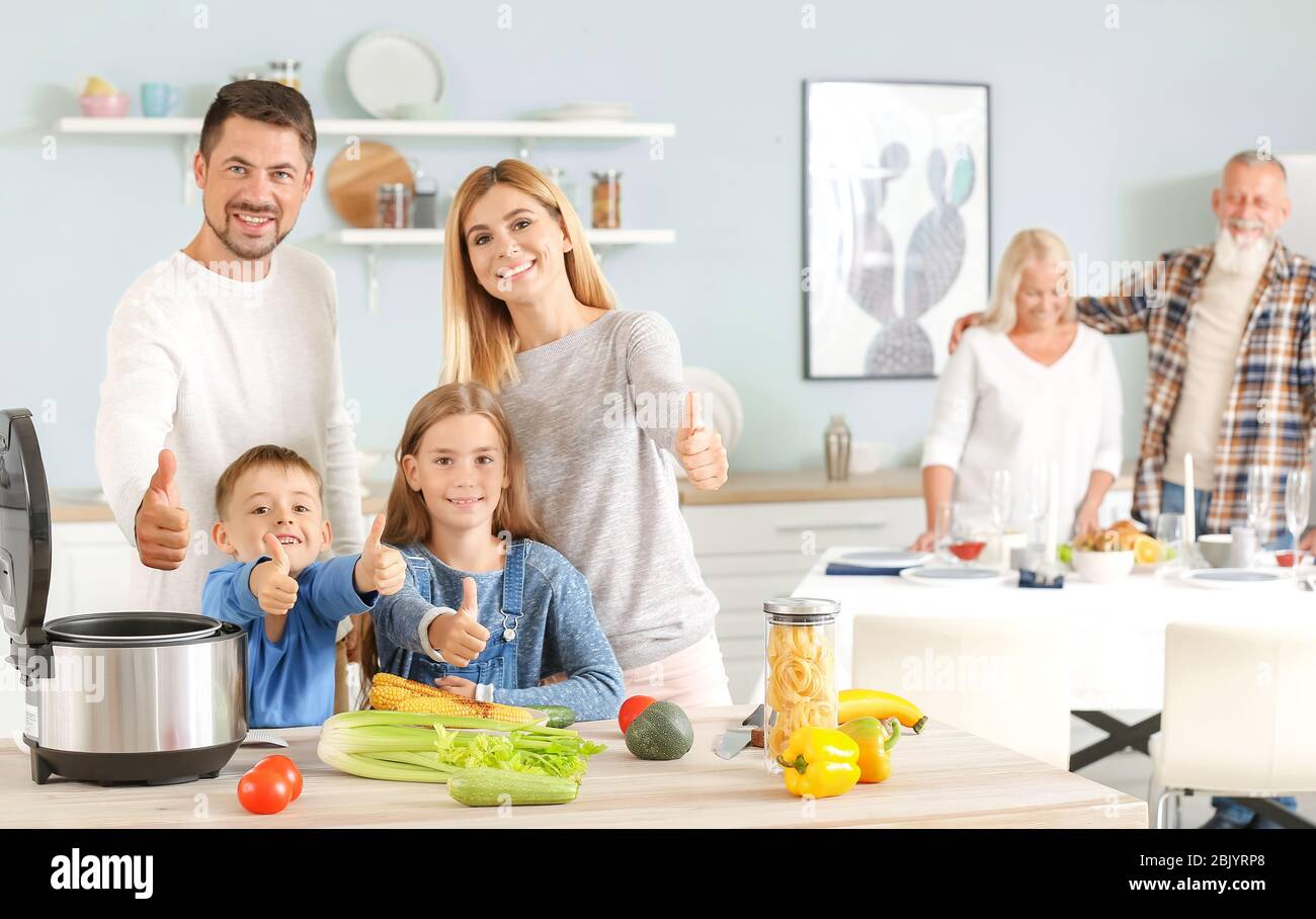 Happy family with modern multi cooker showing thumb-up gesture in ...