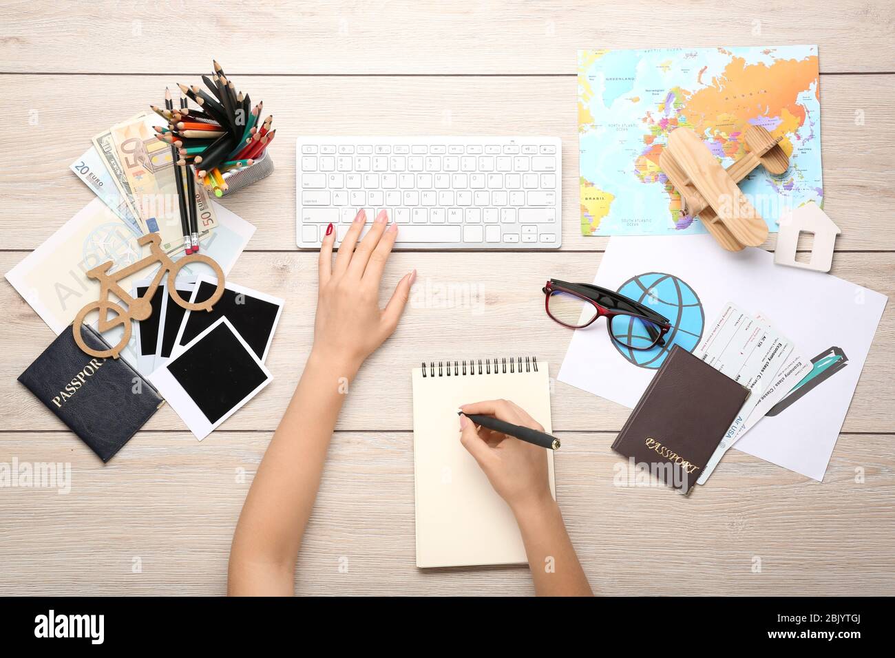 Hands of female travel blogger with computer keyboard, notebook, map ...