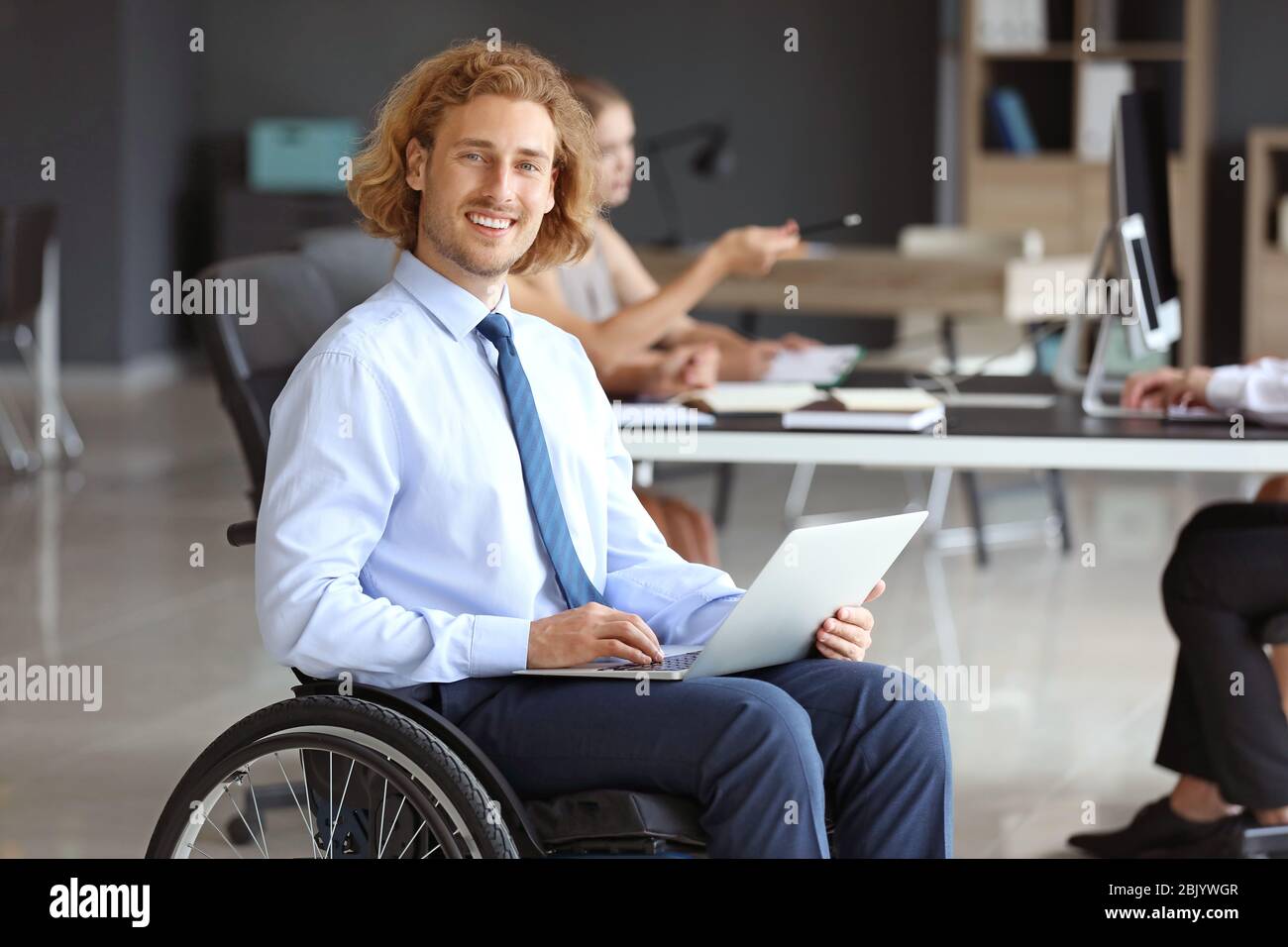 Handicapped young man working in office Stock Photo - Alamy