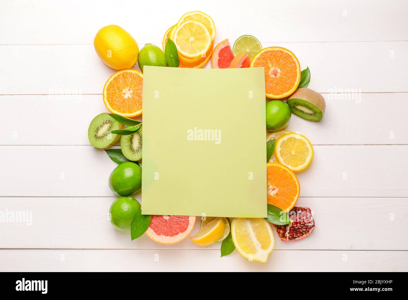 Different fruits and blank card on white wooden background Stock Photo ...