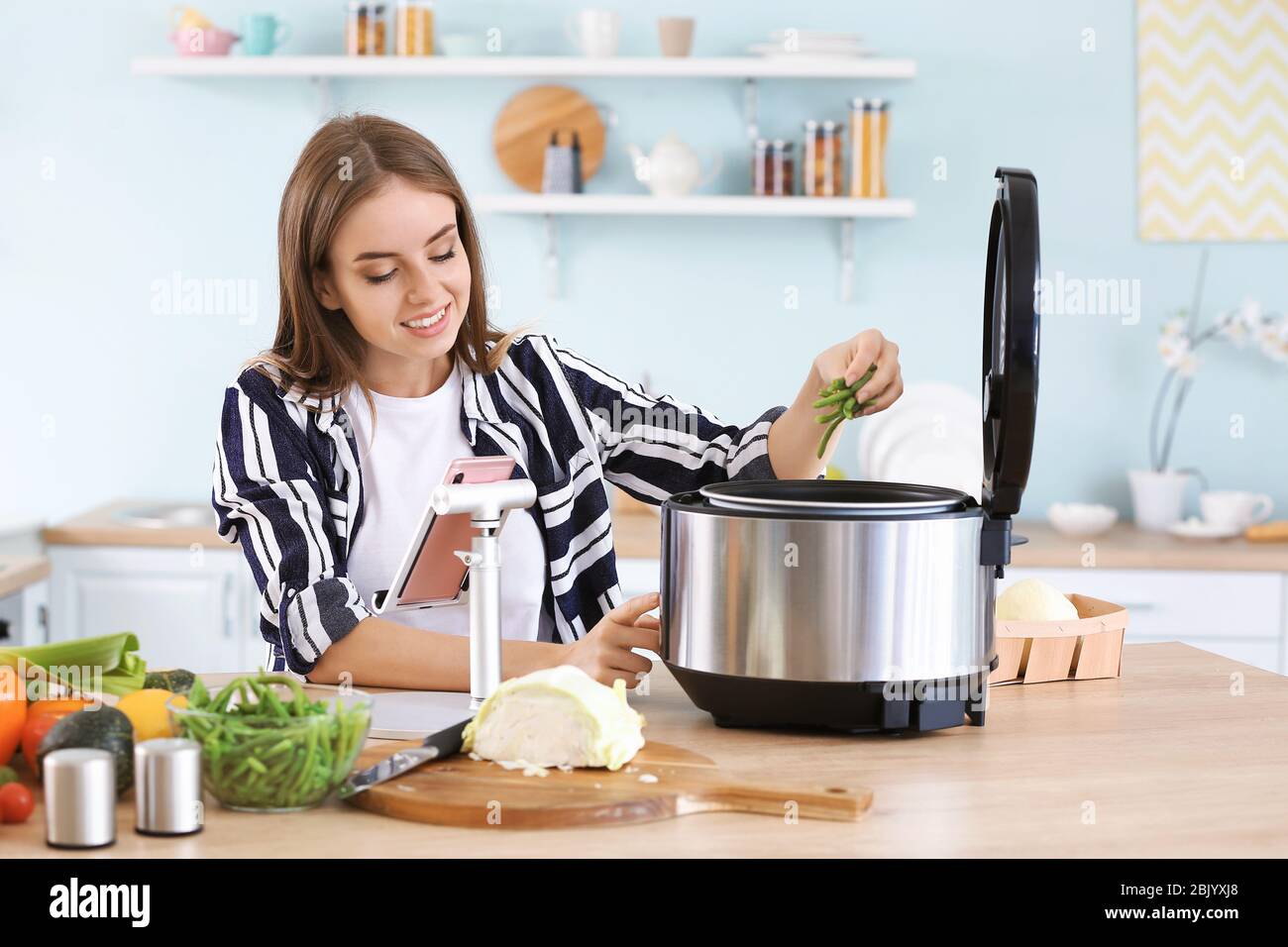 Woman using modern multi cooker in kitchen Stock Photo - Alamy