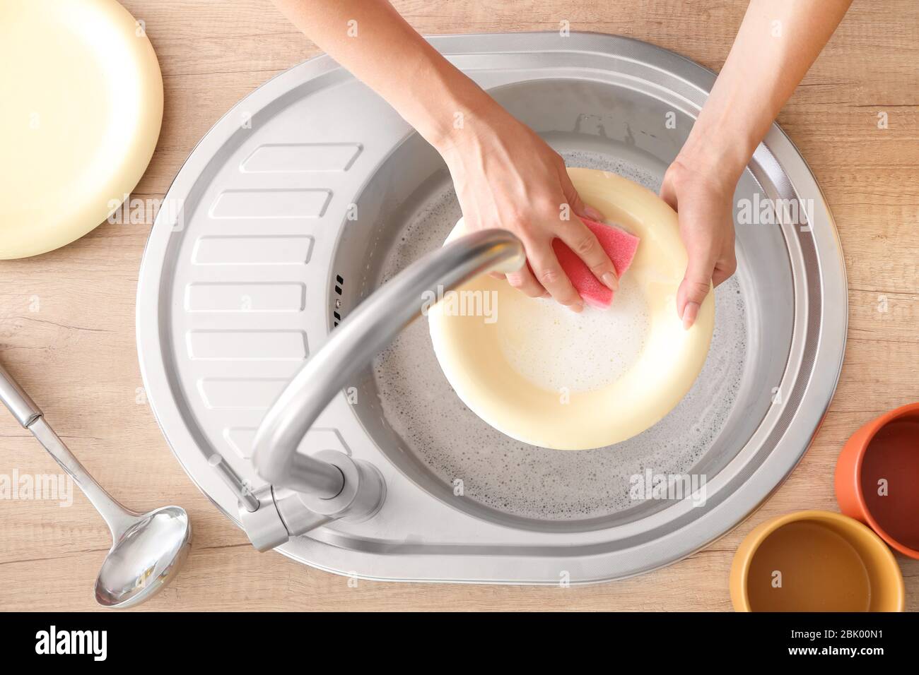 Woman washing dishes in kitchen sink, top view Stock Photo - Alamy
