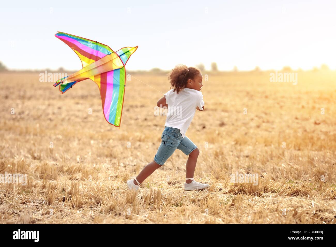 Little African-American girl flying kite outdoors Stock Photo - Alamy