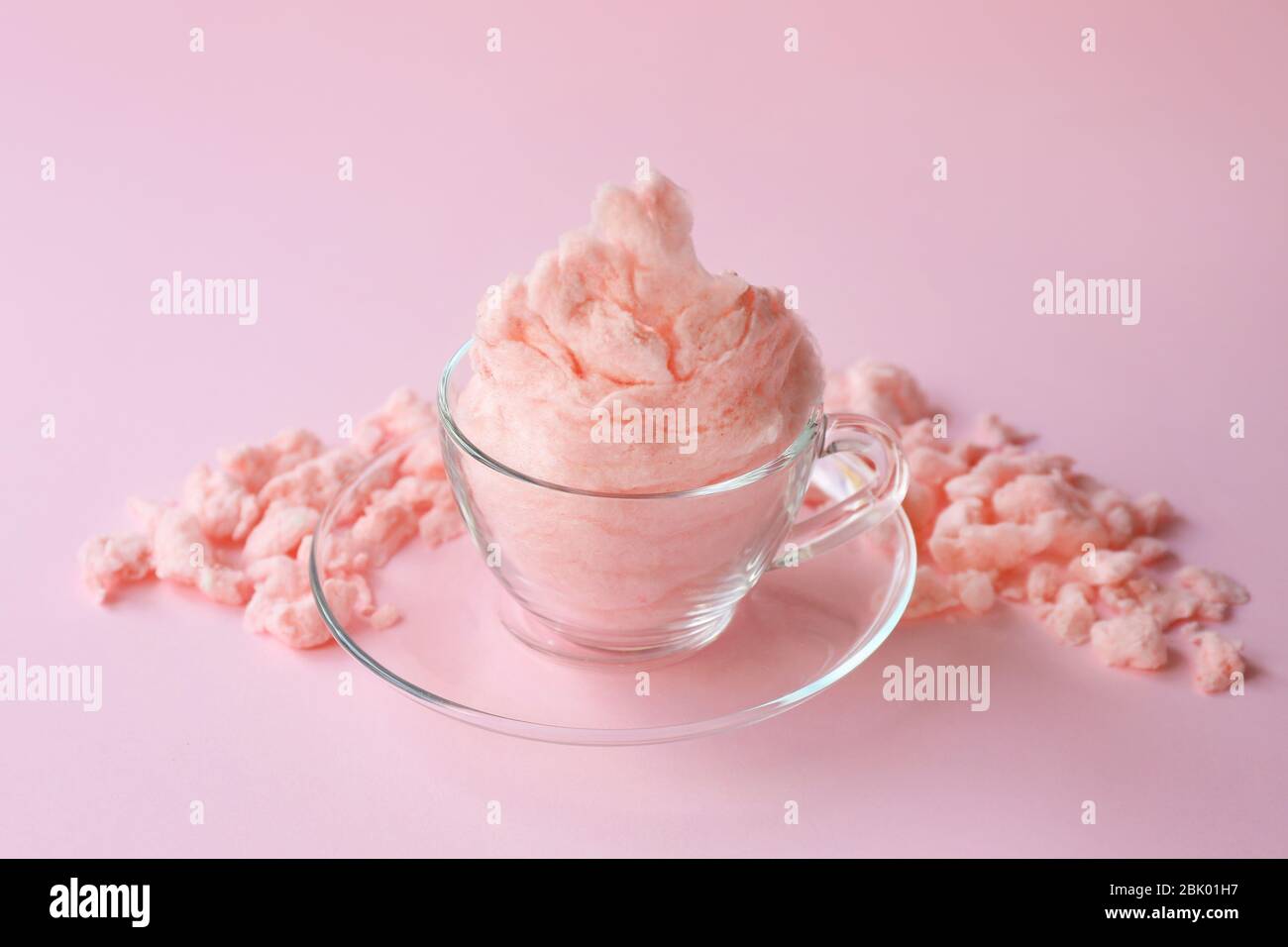 Glass cup with tasty cotton candy on color background Stock Photo - Alamy