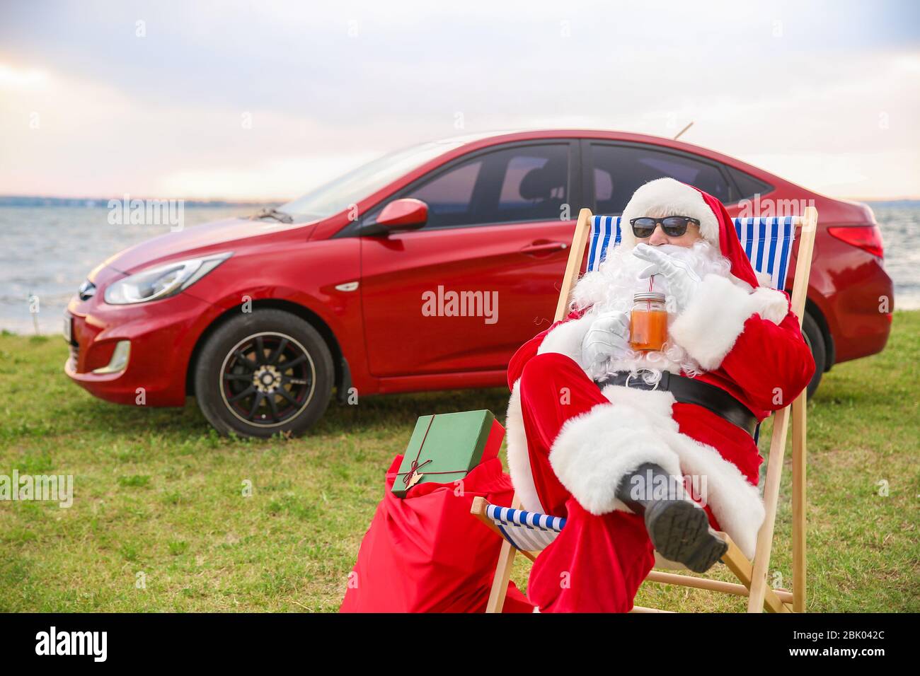 Cool Santa Claus with cocktail resting on riverside Stock Photo - Alamy