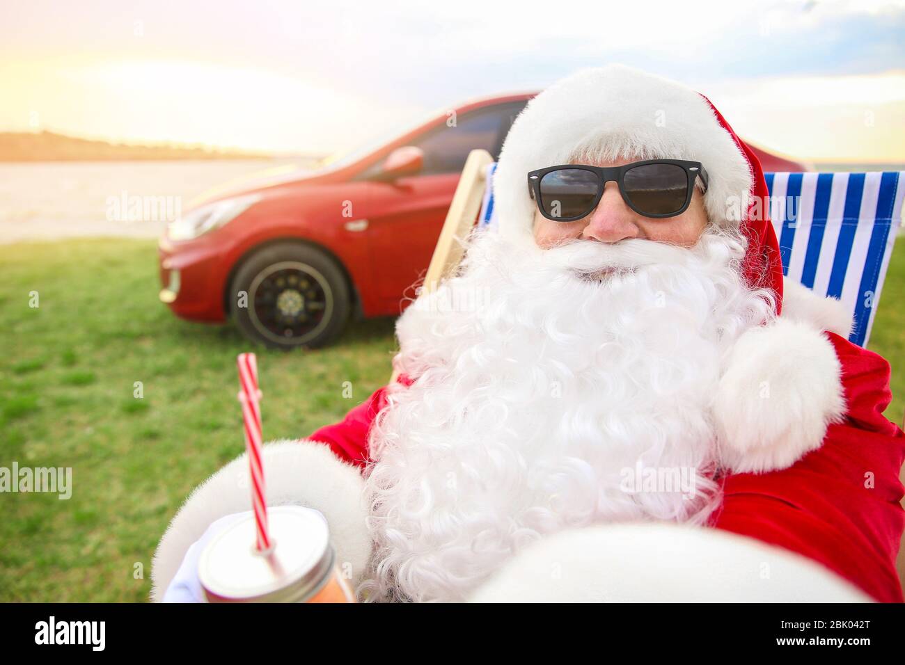 Cool Santa Claus with cocktail resting on riverside Stock Photo - Alamy