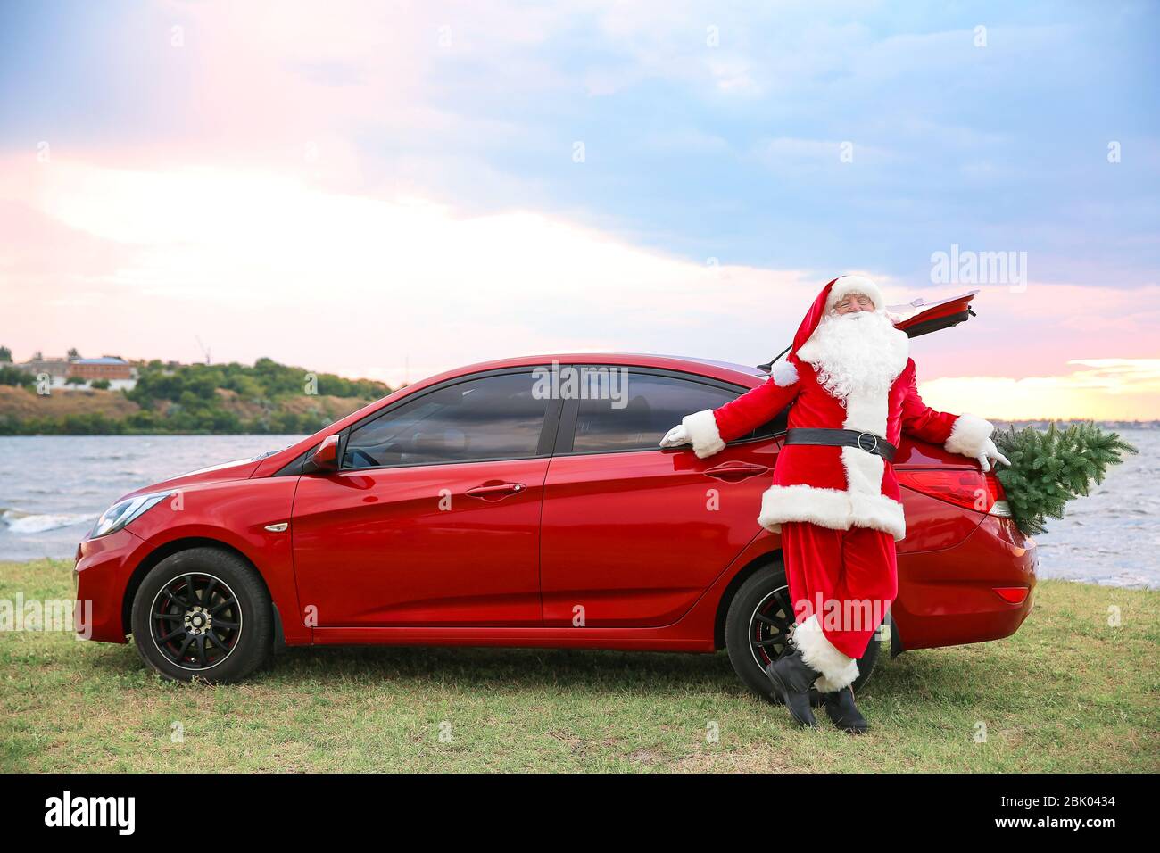 Santa Claus with fir tree in car trunk on riverside Stock Photo - Alamy