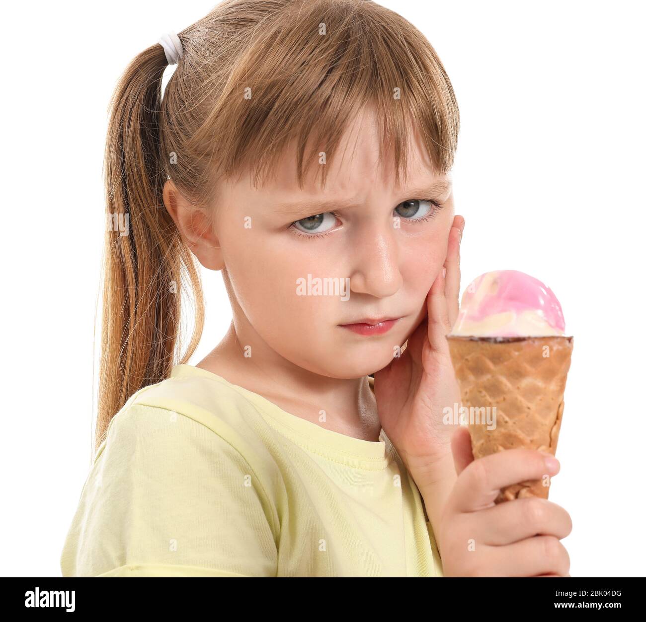 Little girl with sensitive teeth and cold ice-cream on white background ...