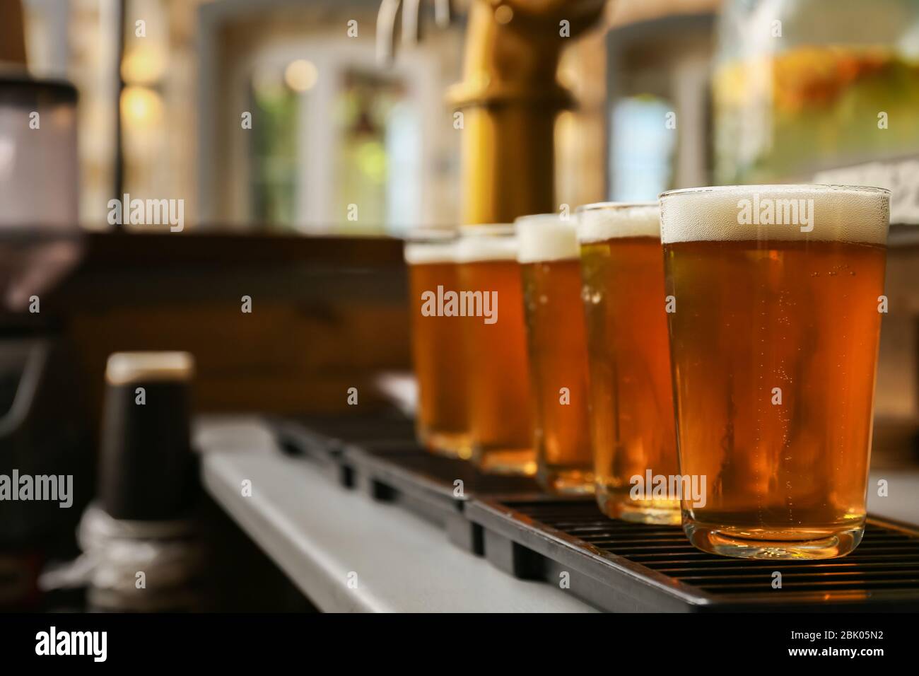 Glasses of fresh draft beer on bar counter Stock Photo - Alamy