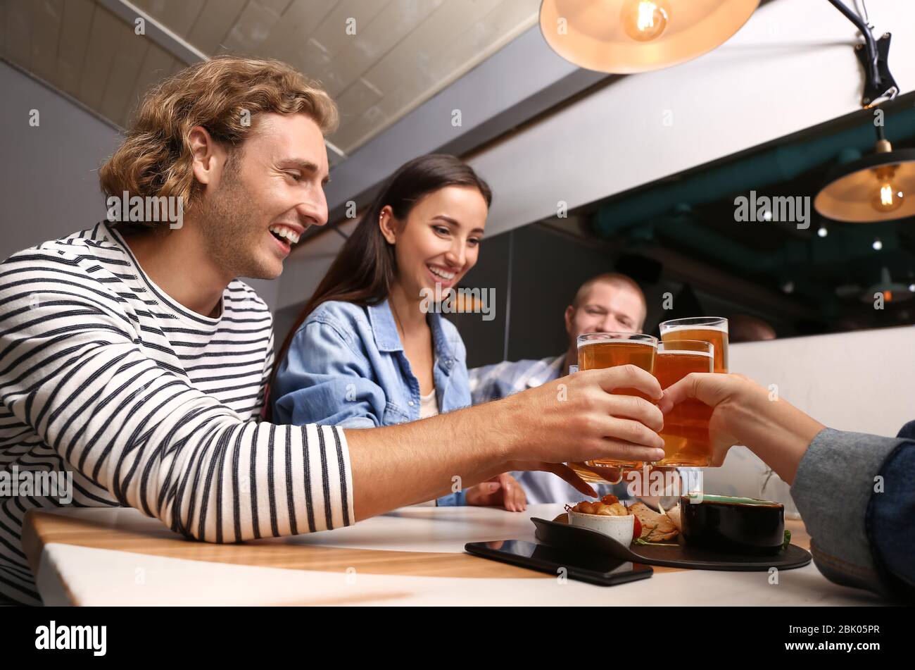 Friends drinking fresh beer in pub Stock Photo - Alamy