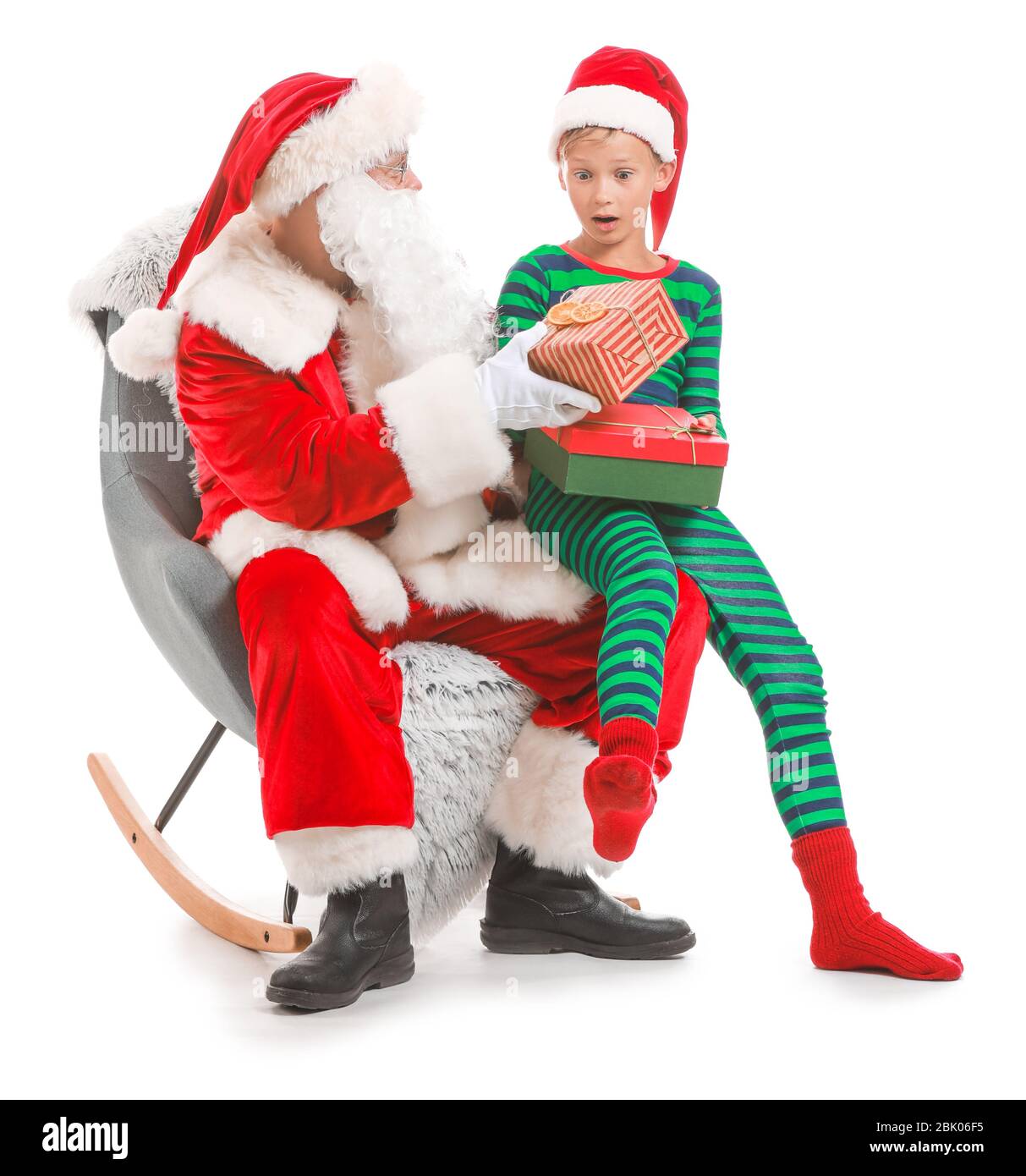 Santa Claus and little elf kid with gifts against white background ...