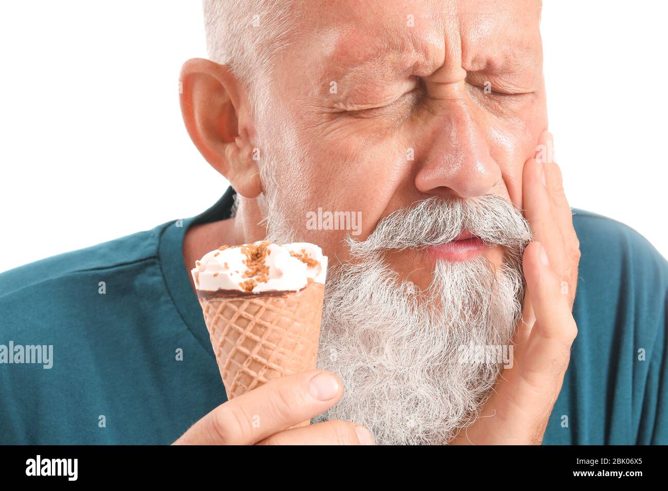 Senior man with sensitive teeth and cold ice-cream on white background ...