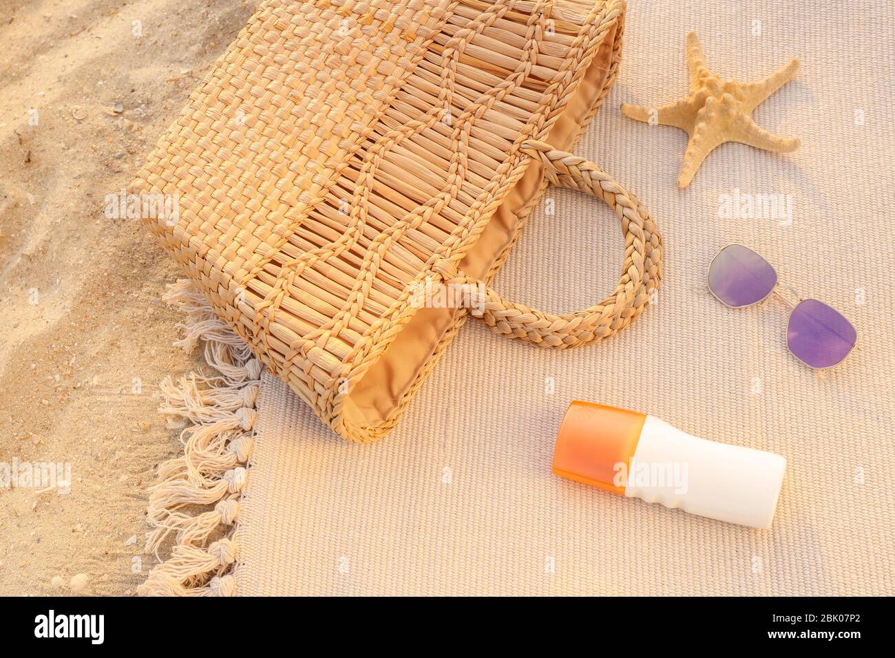 Bag with sunscreen cream, sunglasses and starfish on sand beach Stock ...