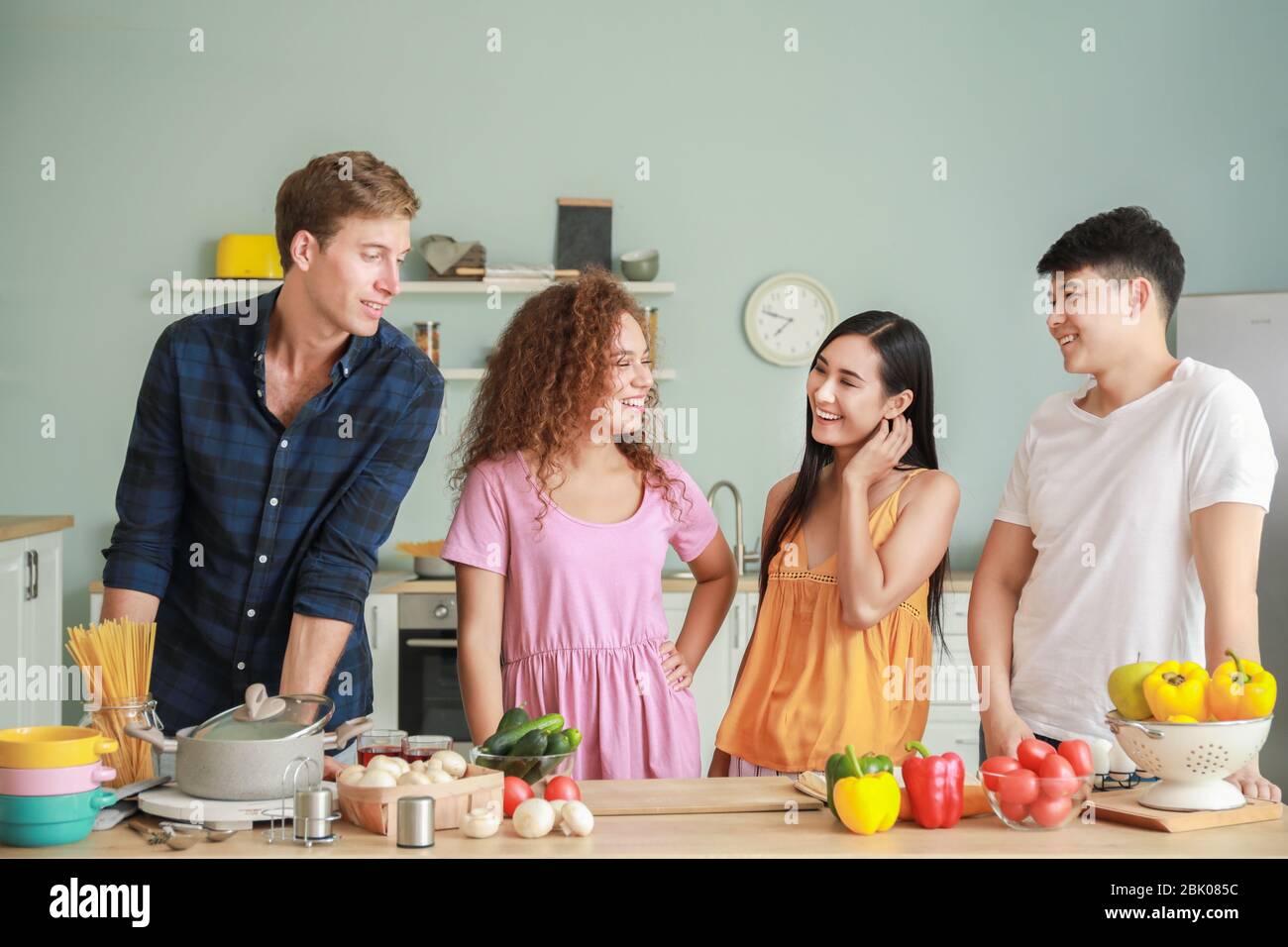 Happy friends cooking together in kitchen Stock Photo - Alamy