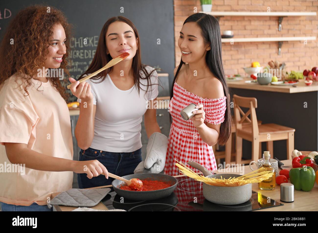 Beautiful women cooking together in kitchen Stock Photo - Alamy