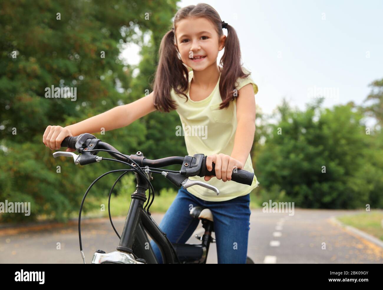 Little girl riding bicycle outdoors Stock Photo - Alamy