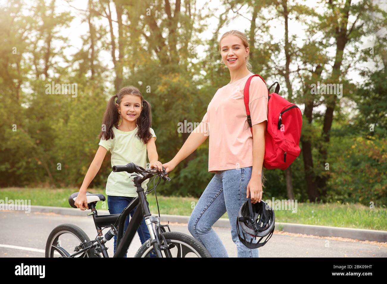 Woman and her little daughter with bicycle outdoors Stock Photo - Alamy