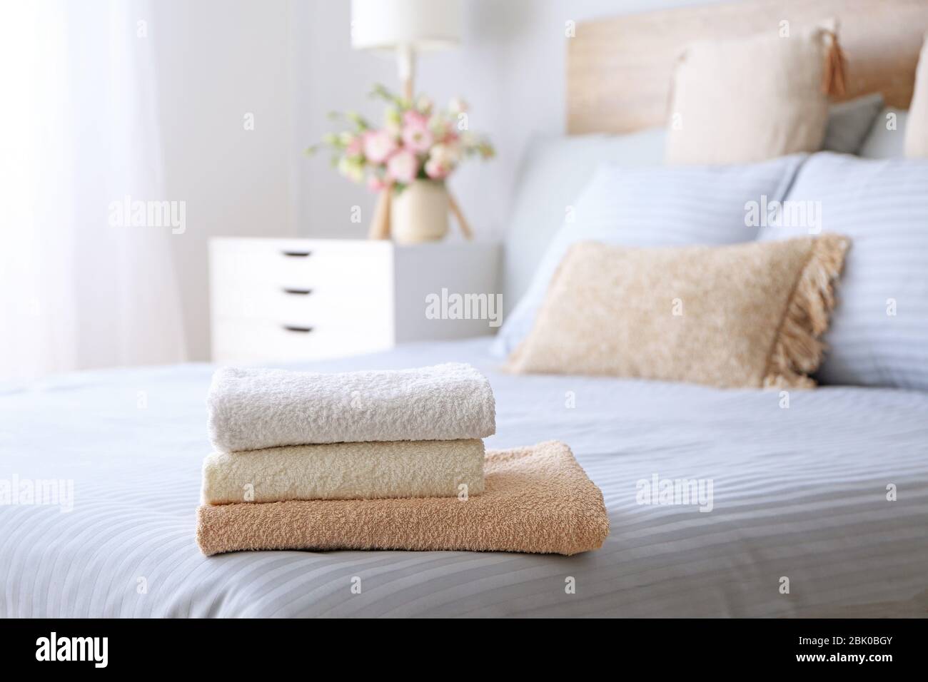 Stack of clean towels on bed Stock Photo - Alamy
