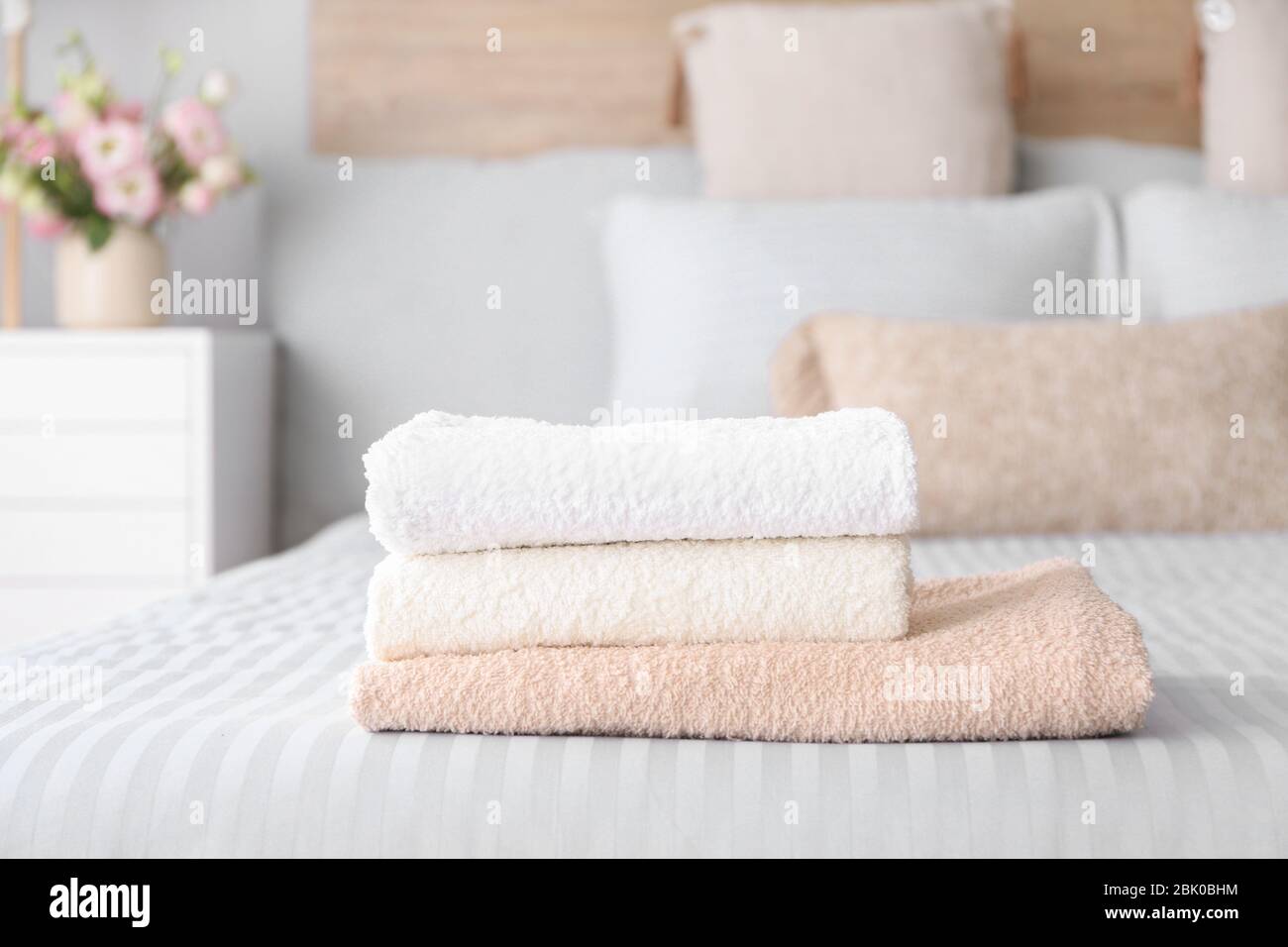 Stack of clean towels on bed Stock Photo - Alamy