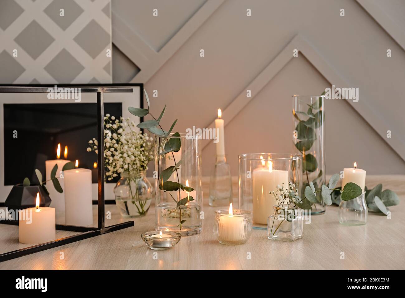 Beautiful burning candles and floral decor on table Stock Photo - Alamy