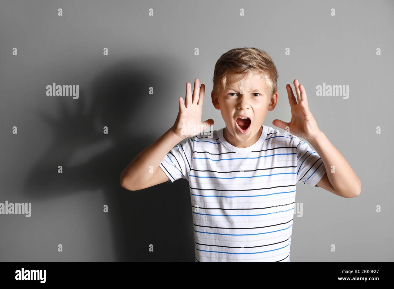 Portrait of angry little boy on grey background Stock Photo - Alamy