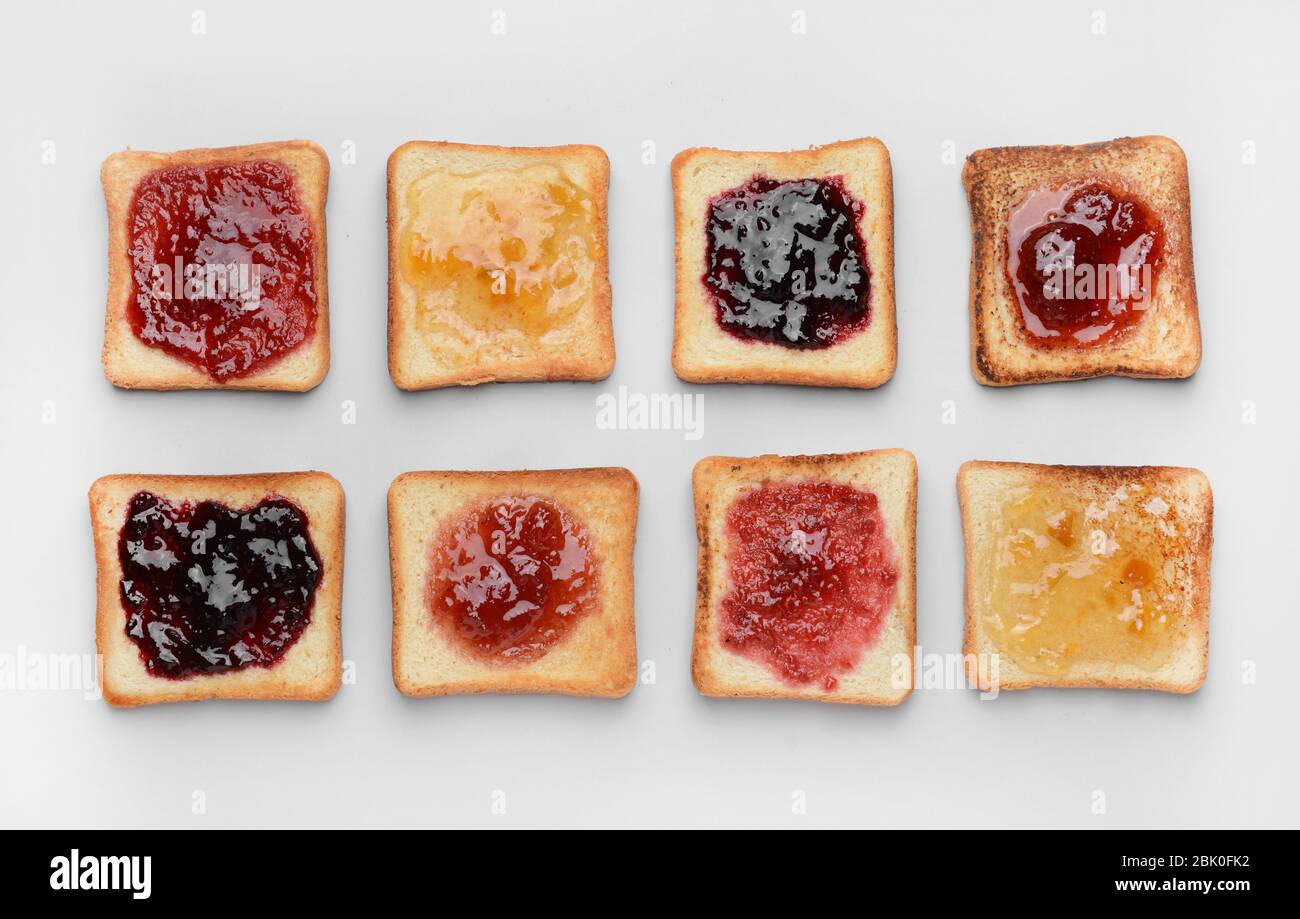 Tasty toasted bread with different jams on white background Stock Photo ...