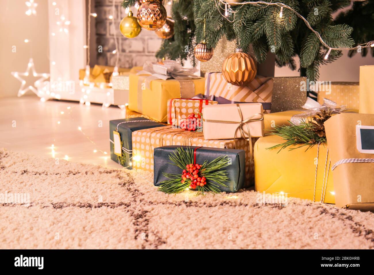Many gift boxes under Christmas tree in room Stock Photo - Alamy