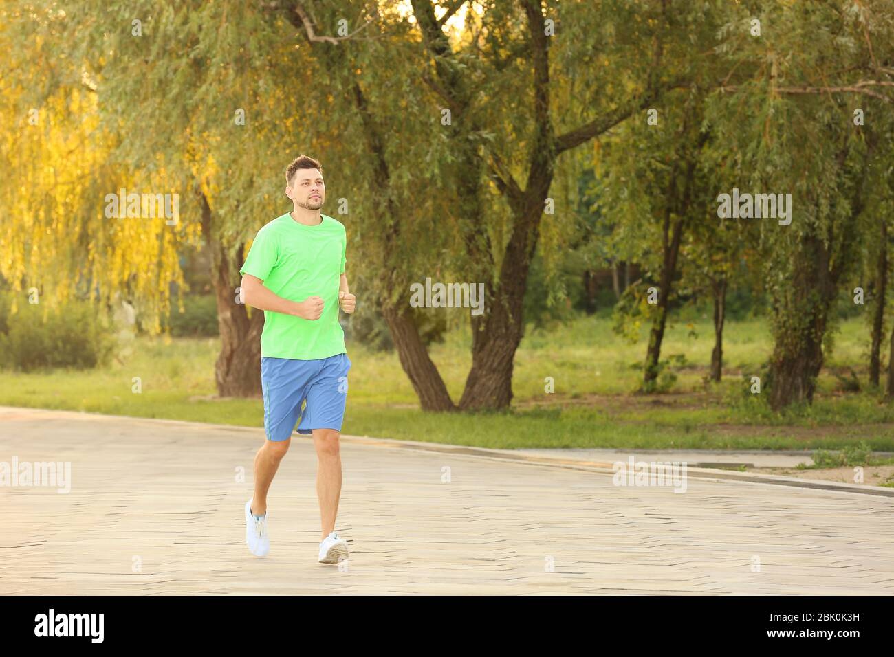 Handsome sporty man running outdoors Stock Photo - Alamy
