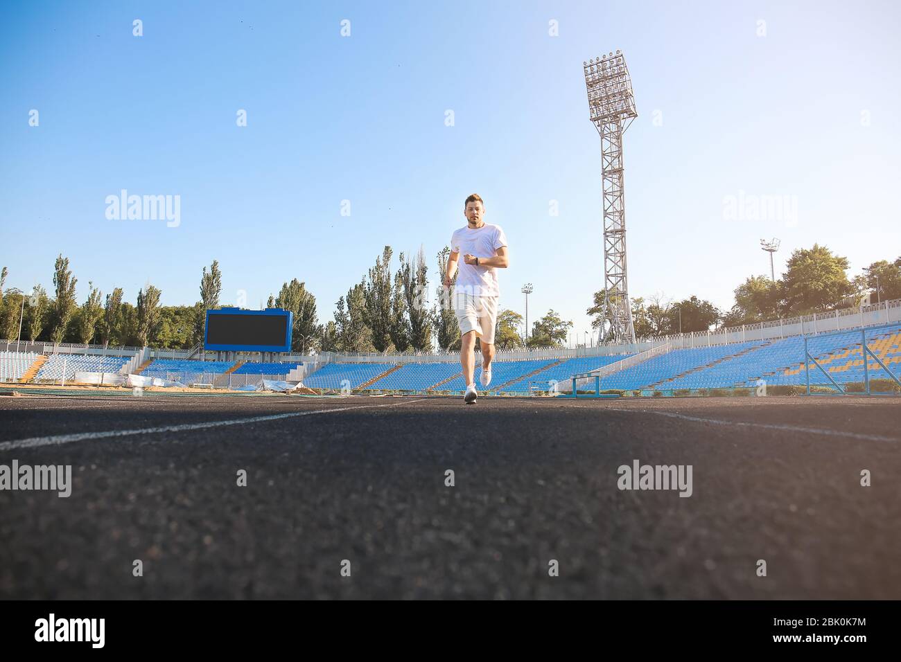 Sporty man running at the stadium Stock Photo - Alamy