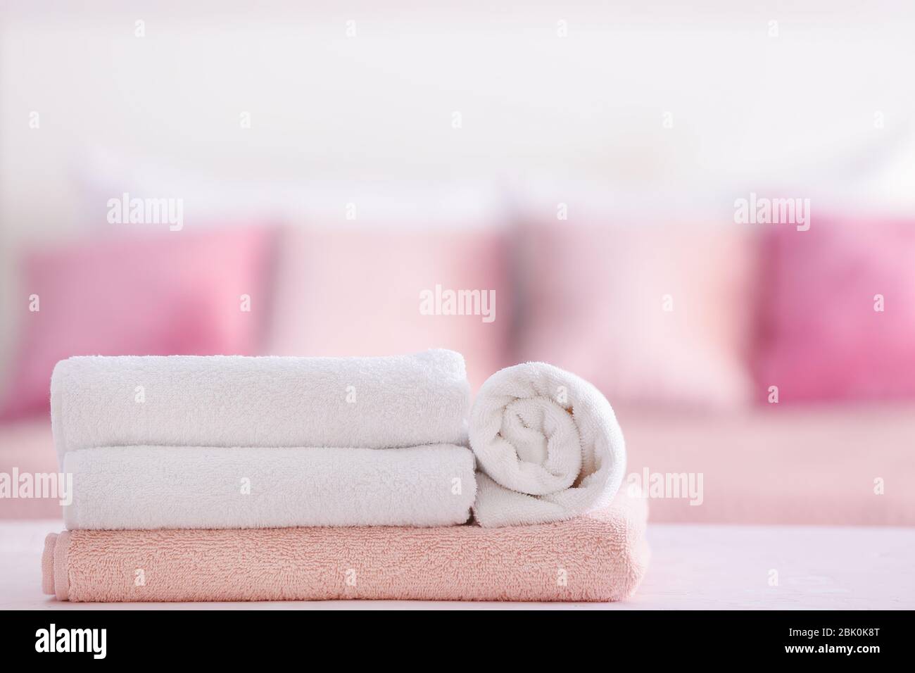 Stack of clean towels on table in bedroom Stock Photo - Alamy
