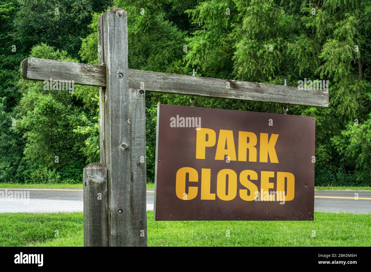 park closed entrance or trailhead sign against green trees, restricted ...