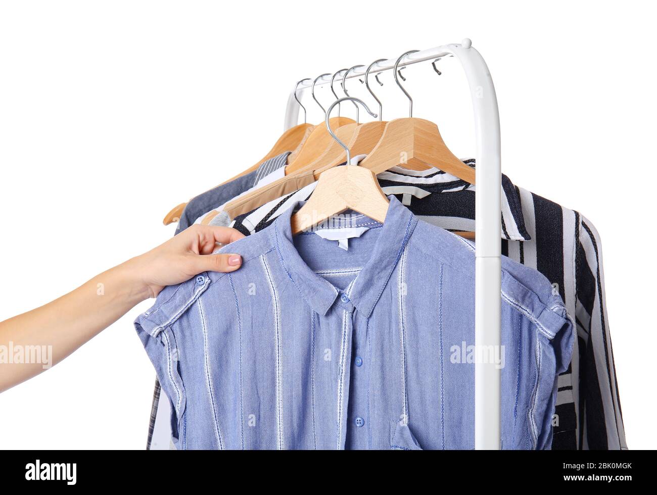 Woman choosing clothes hanging on rack against white background Stock ...