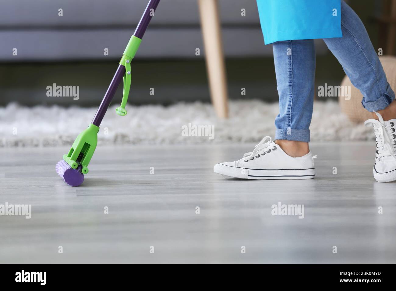 Woman mopping floor in room Stock Photo - Alamy