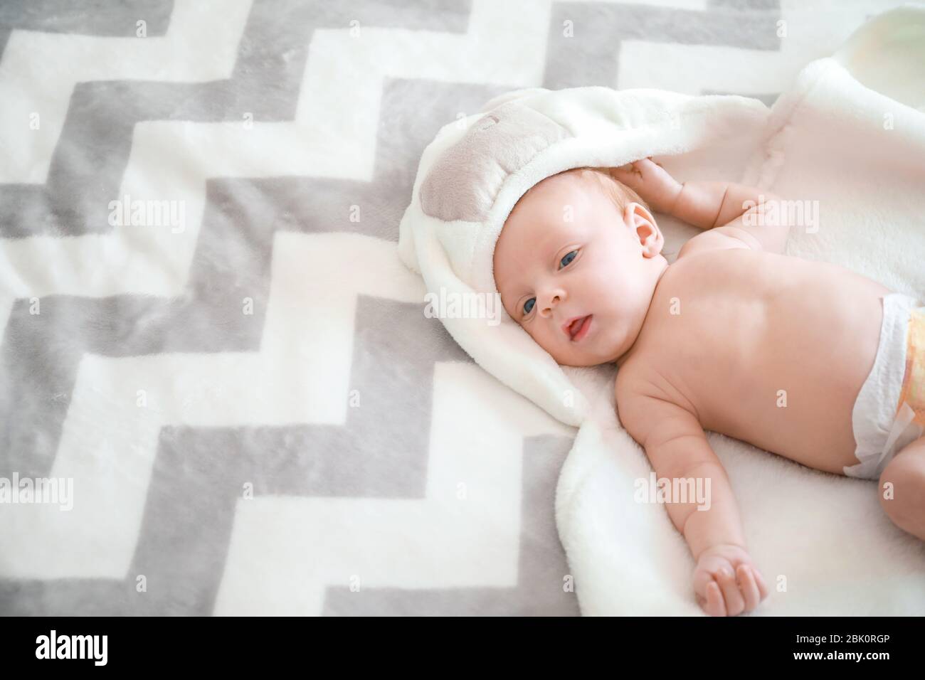 Cute little baby lying on bed Stock Photo - Alamy