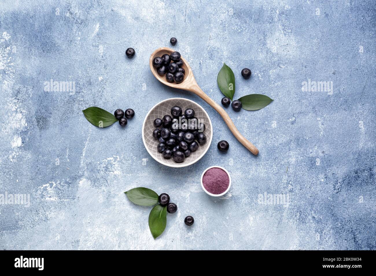 Acai berries with powder on color background Stock Photo - Alamy