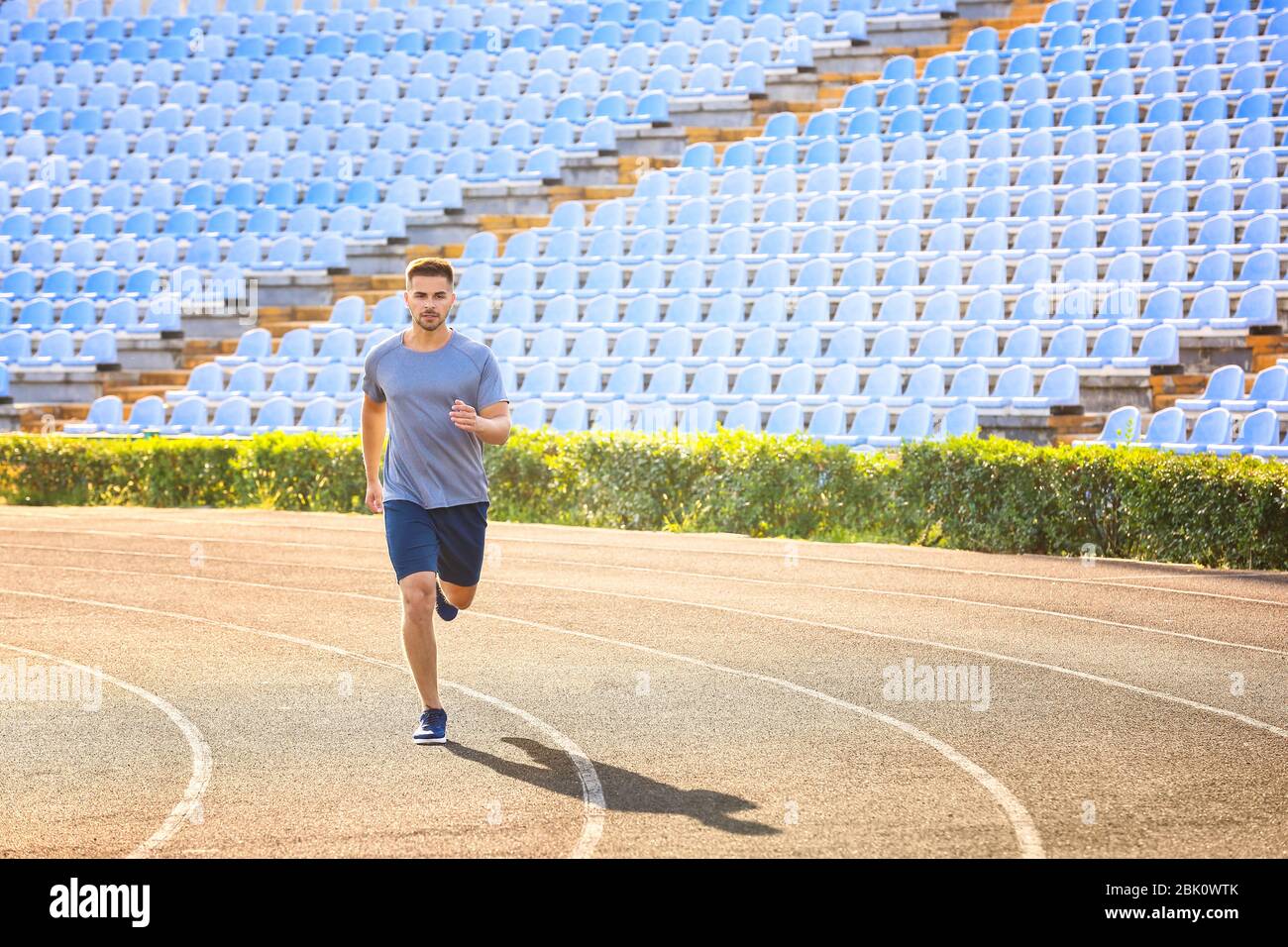 Sporty man running at the stadium Stock Photo - Alamy