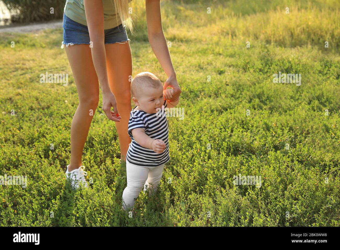 Mother teaching her little baby to walk outdoors Stock Photo - Alamy