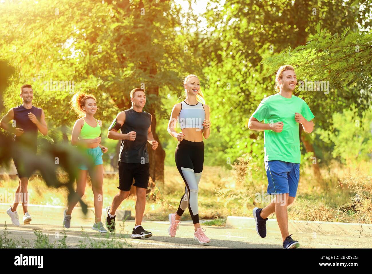 Group of sporty young people running outdoors Stock Photo - Alamy