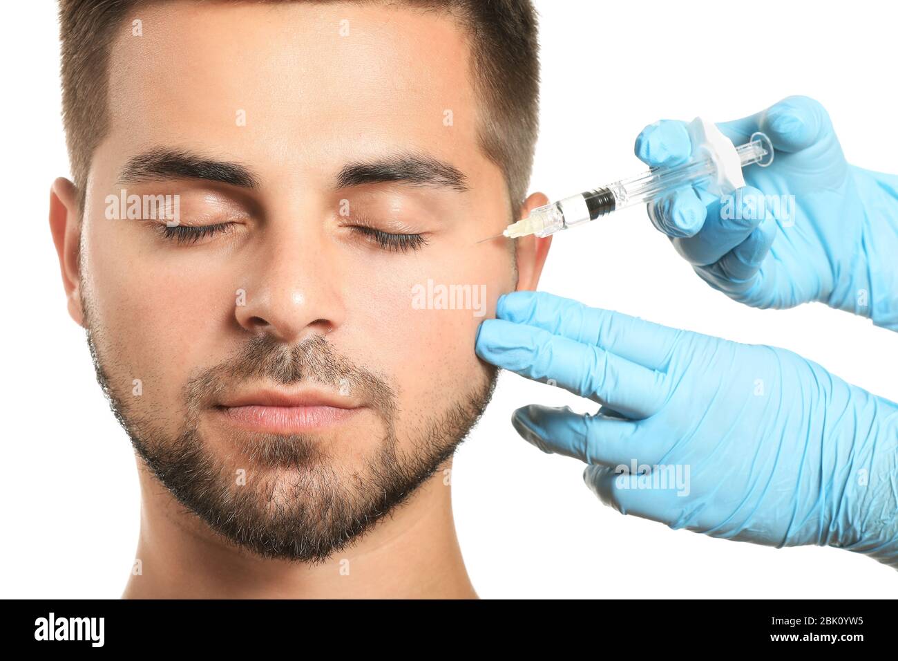 Handsome man receiving filler injection on white background Stock Photo ...