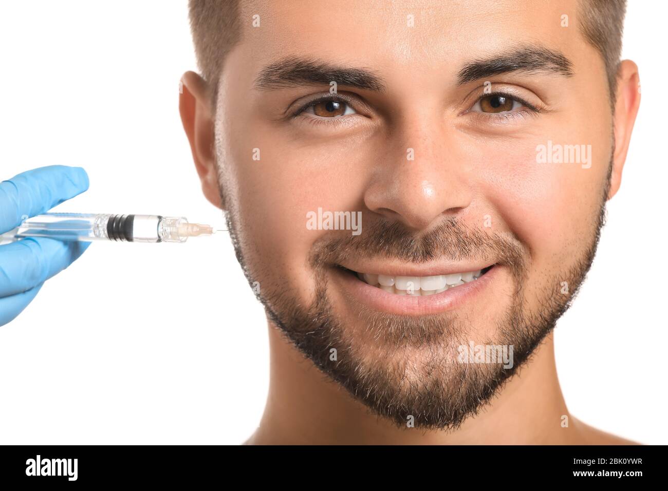 Handsome man receiving filler injection on white background Stock Photo ...