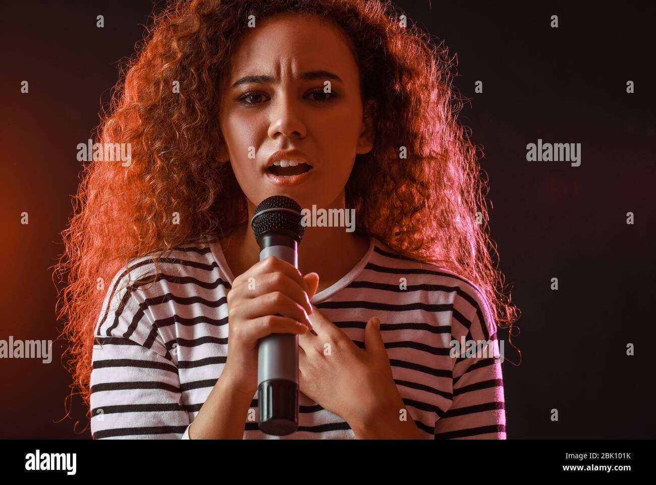 Beautiful African-American female singer with microphone on stage Stock ...