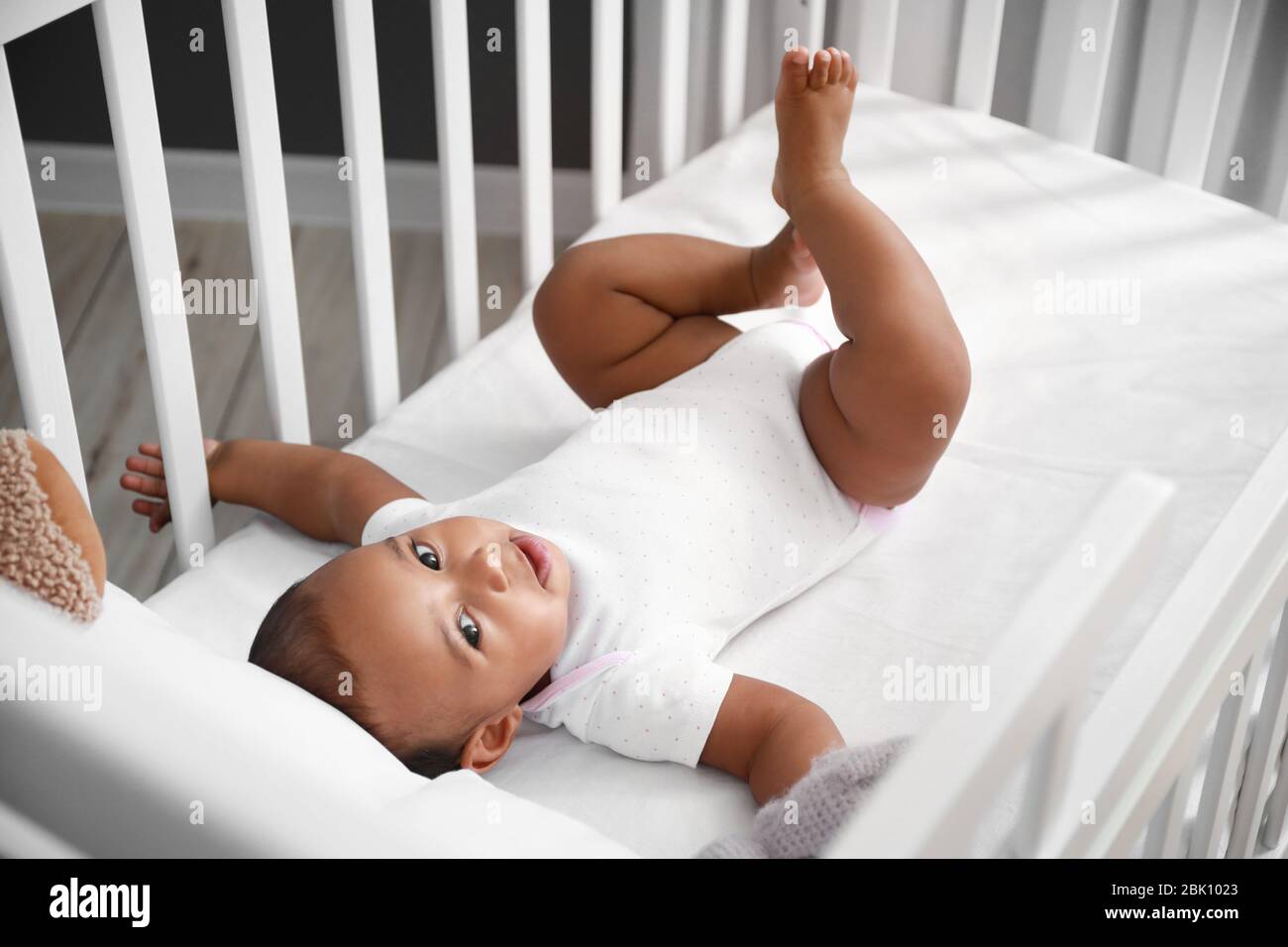 Cute little African-American baby in crib Stock Photo - Alamy