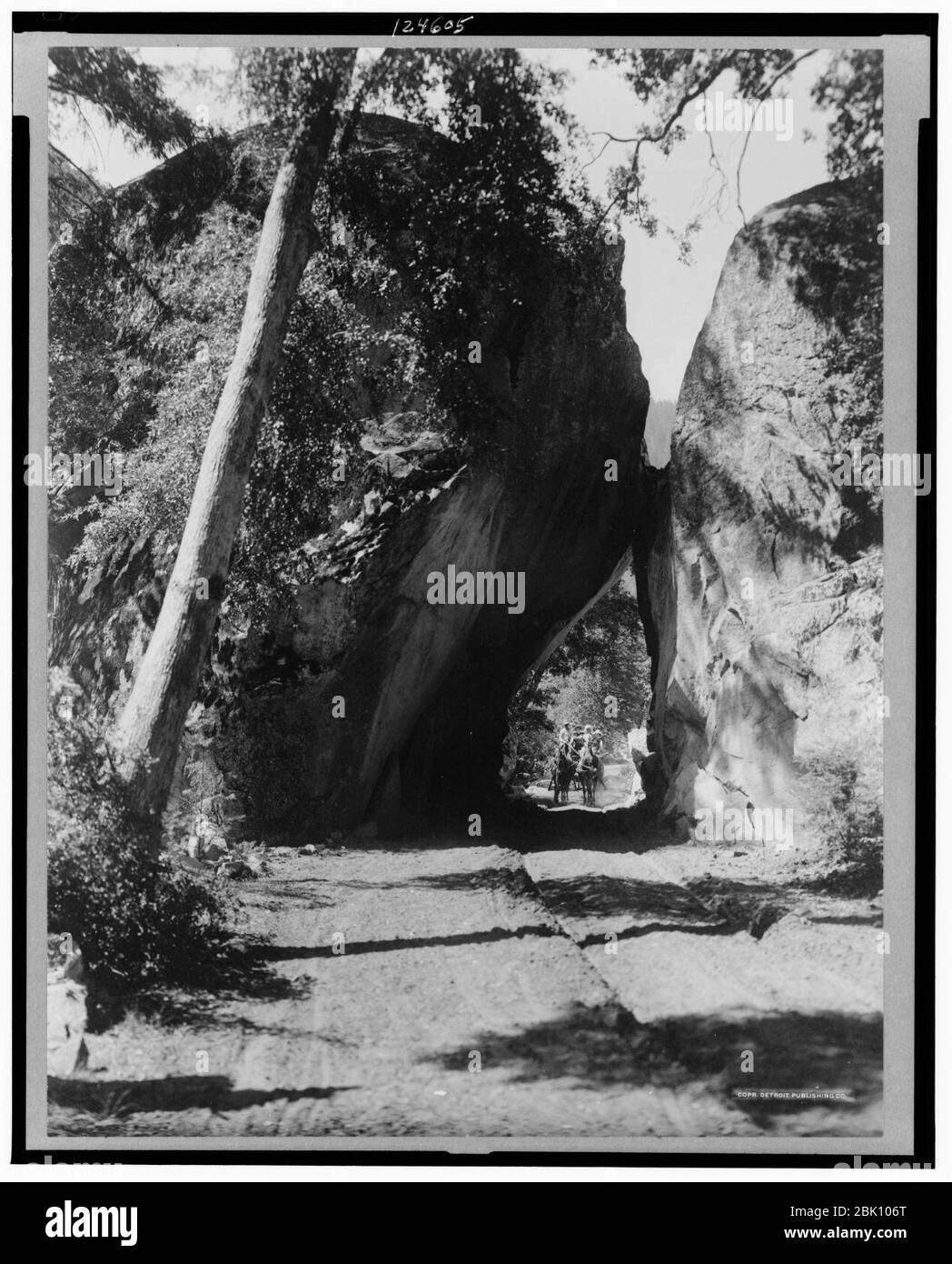 Horse drawn carriage coming through Arch Rock, a large rock formation ...