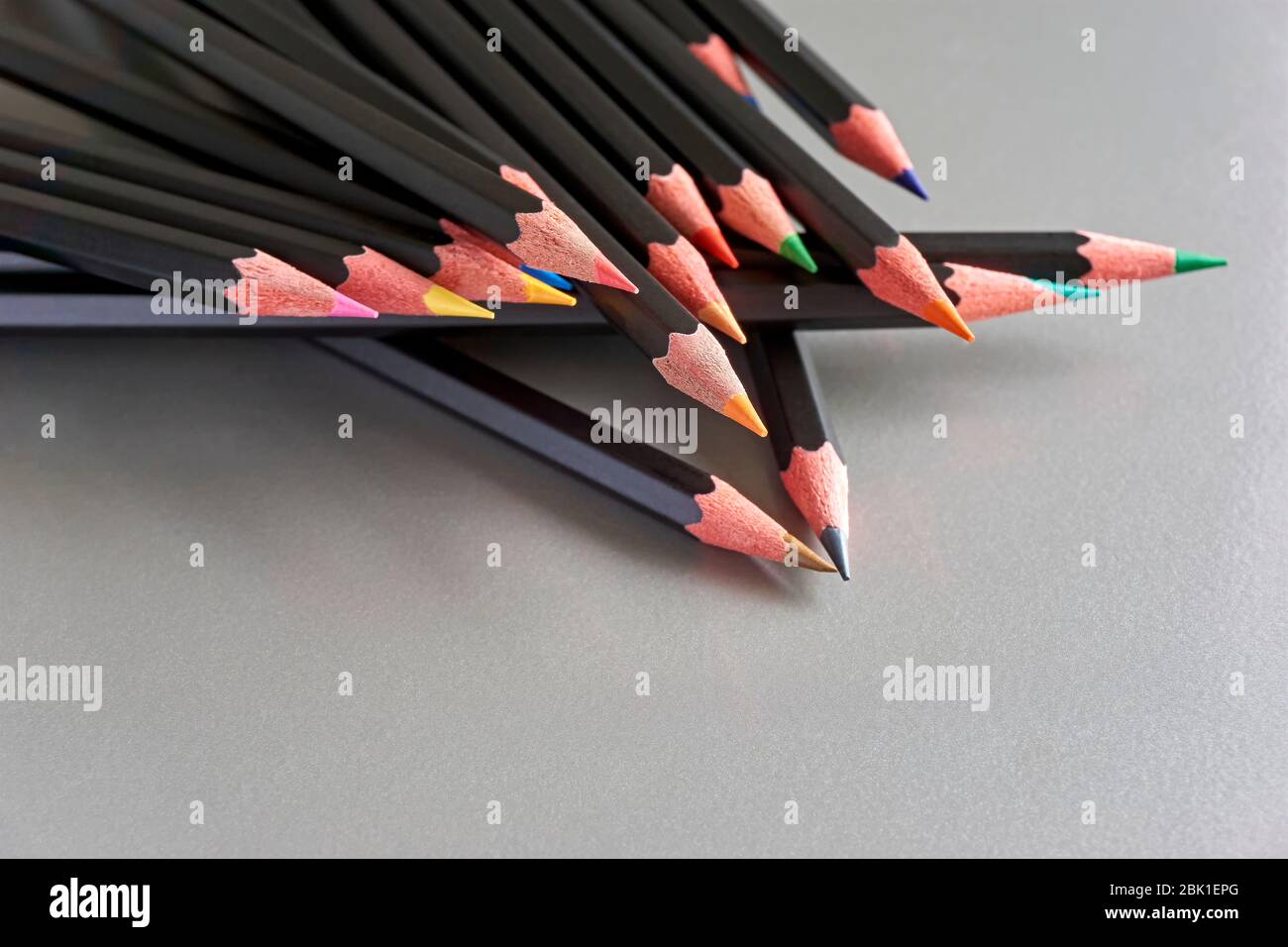 Closeup of a group of black colored pencils on a grey metallic ...