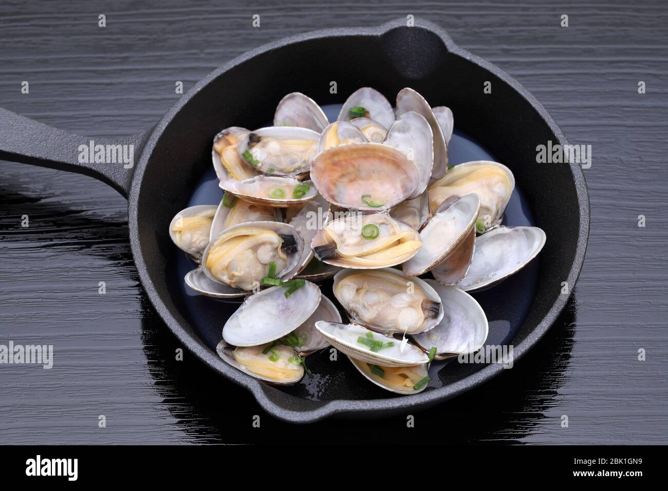 Japanese traditional cuisine, Sake steamed clams, Sakamushi, on table ...