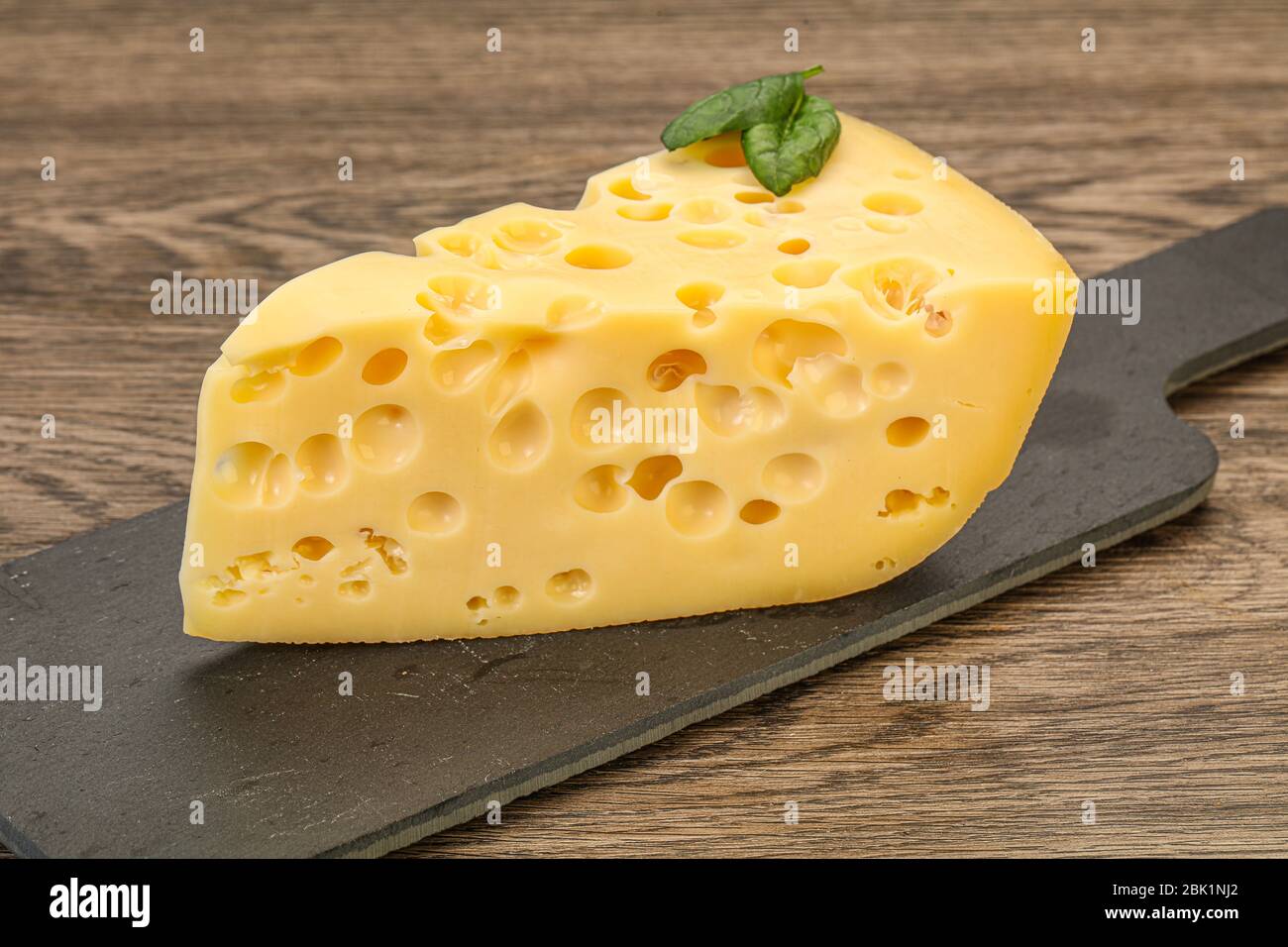Maasdam cheese - dairy yellow triangle with holes Stock Photo - Alamy