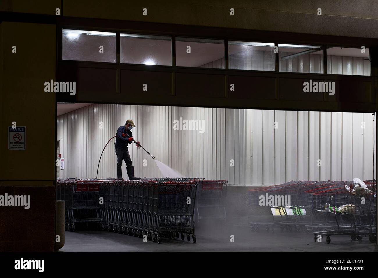 Bend, Oregon, USA. 30th Apr, 2020. A Costco employee spray cleans and ...