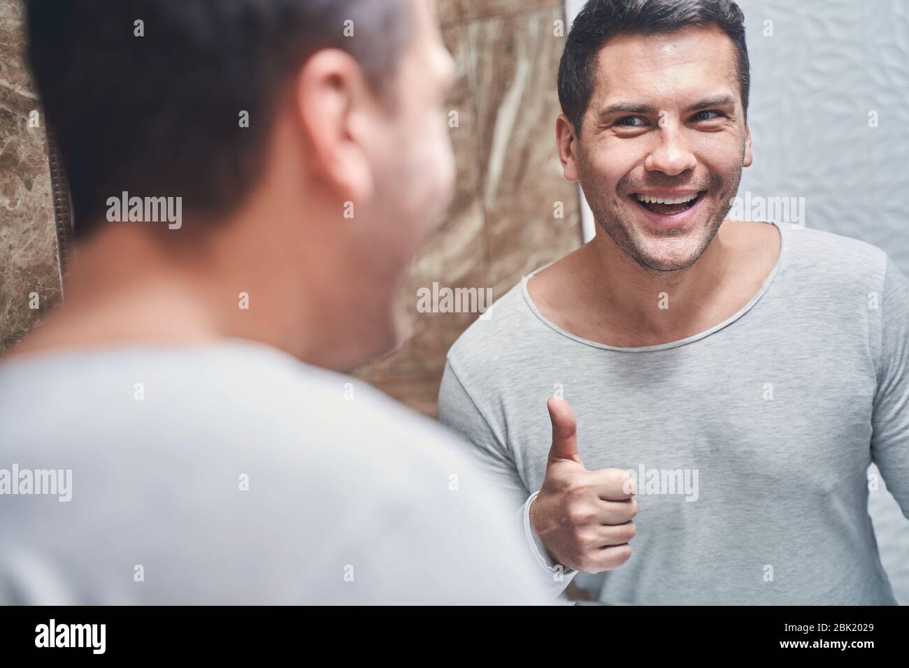 Man admiring his looks in the mirror Stock Photo - Alamy