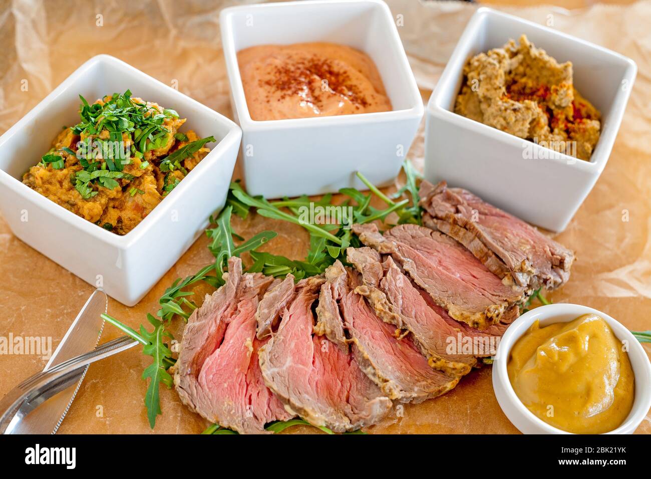 Bowls with various starters and sliced roast beef Stock Photo - Alamy